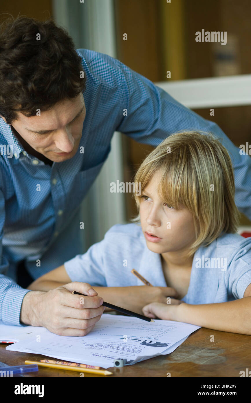 Male junior high student listening as teacher explains difficult ...
