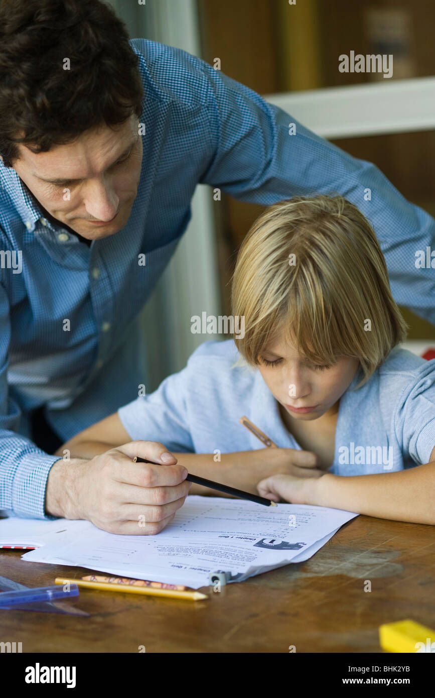 Male junior high student looks as teacher checks assignment, close-up ...