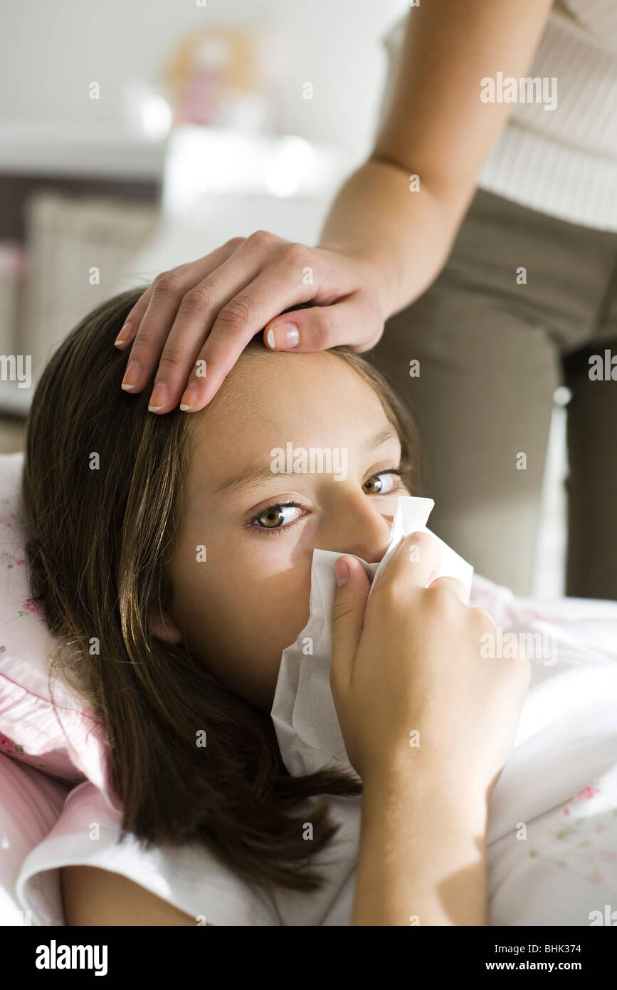 Girl with head cold, mother caressing forehead Stock Photo - Alamy