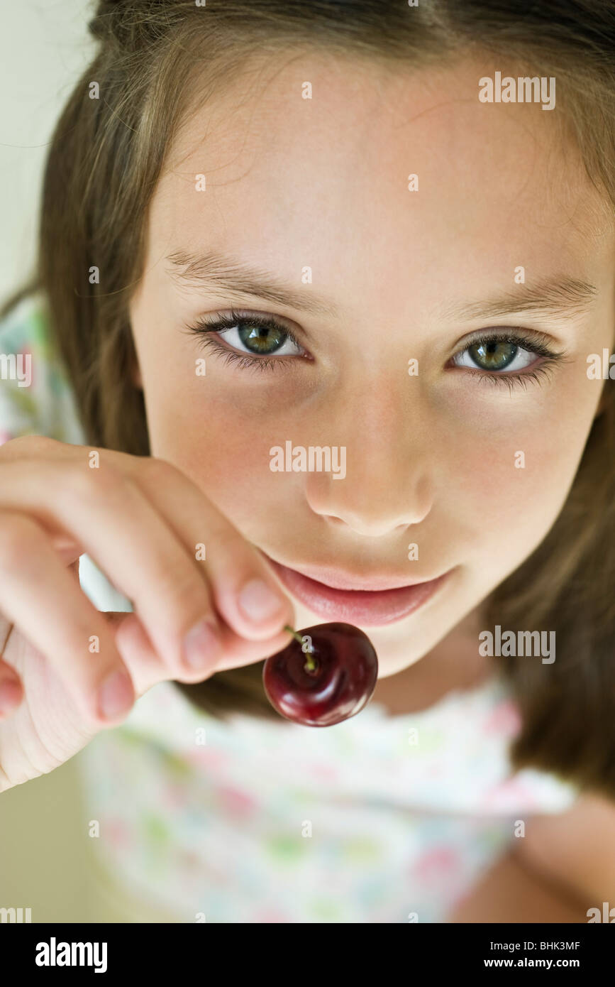 Girl eating cherry Stock Photo - Alamy