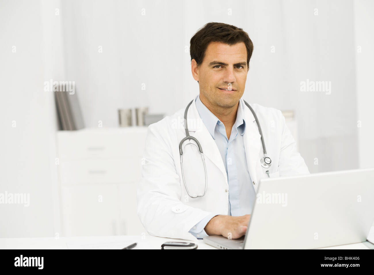 Doctor using laptop computer, portrait Stock Photo - Alamy