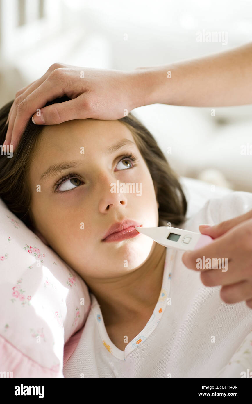 Mother checking daughter's temperature, caressing forehead, cropped ...