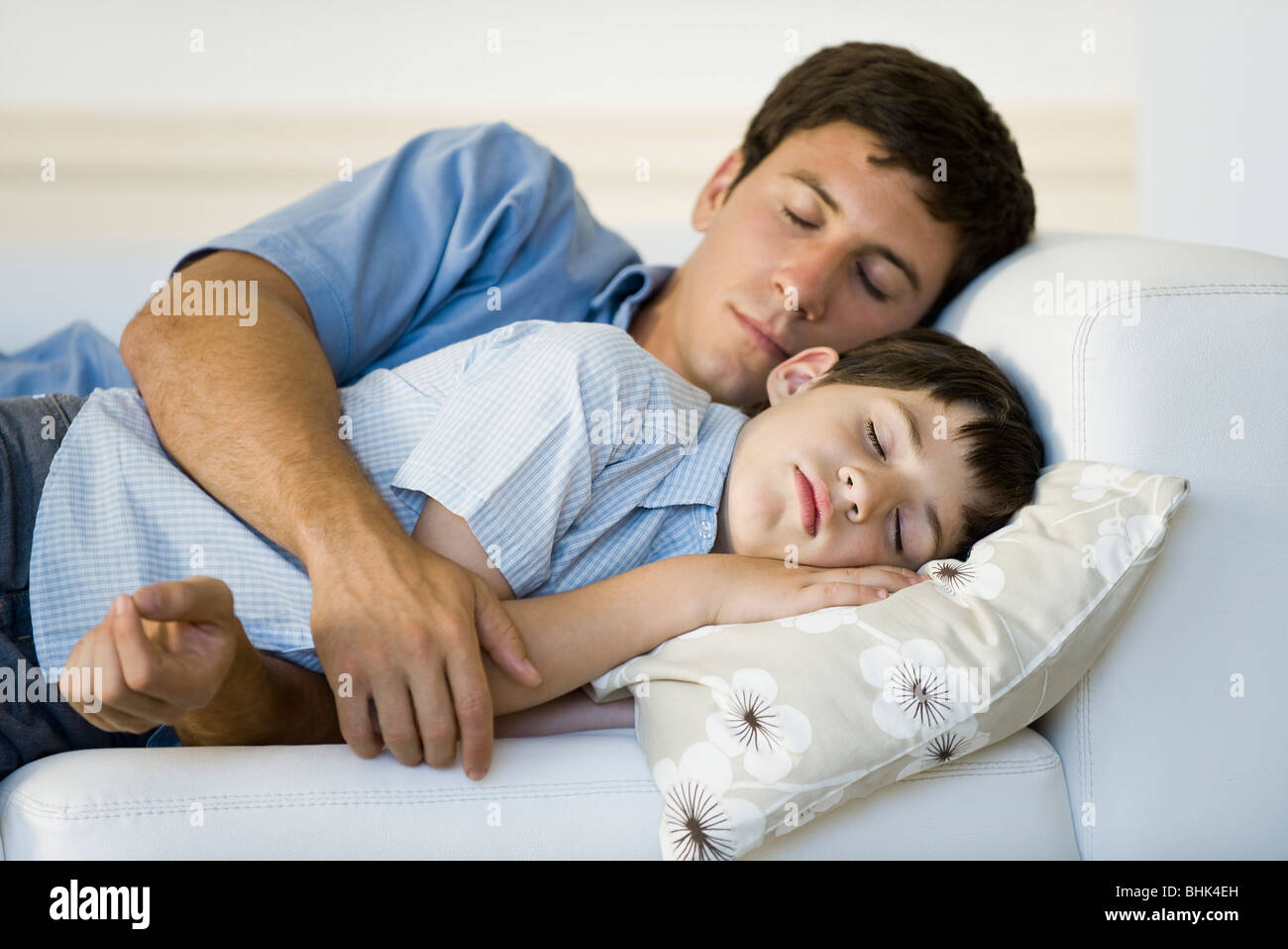 Father and son napping together on sofa Stock Photo - Alamy