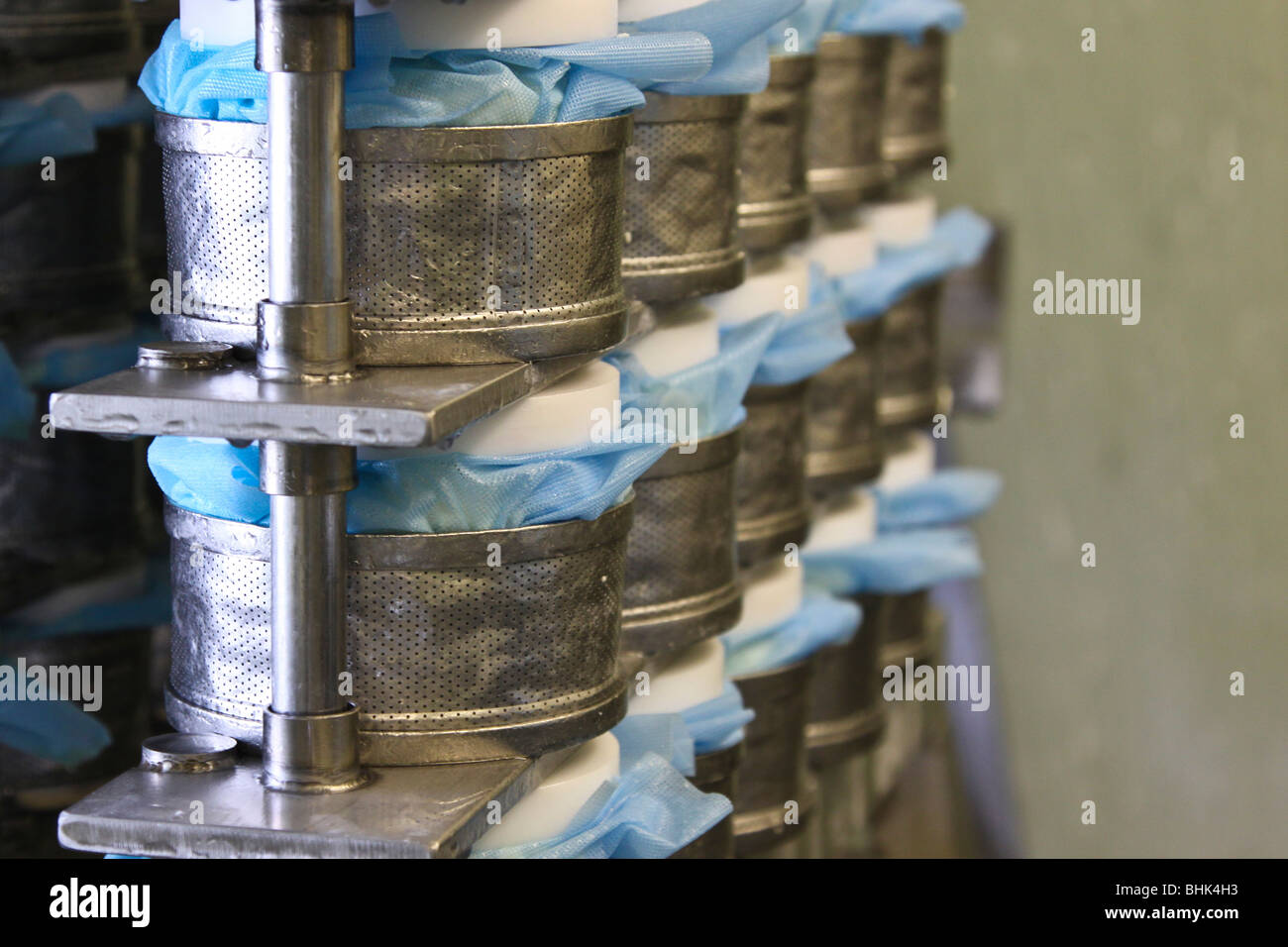 Cheese molds on shelves in a cheese making facility, Grimbister, Orkney ...