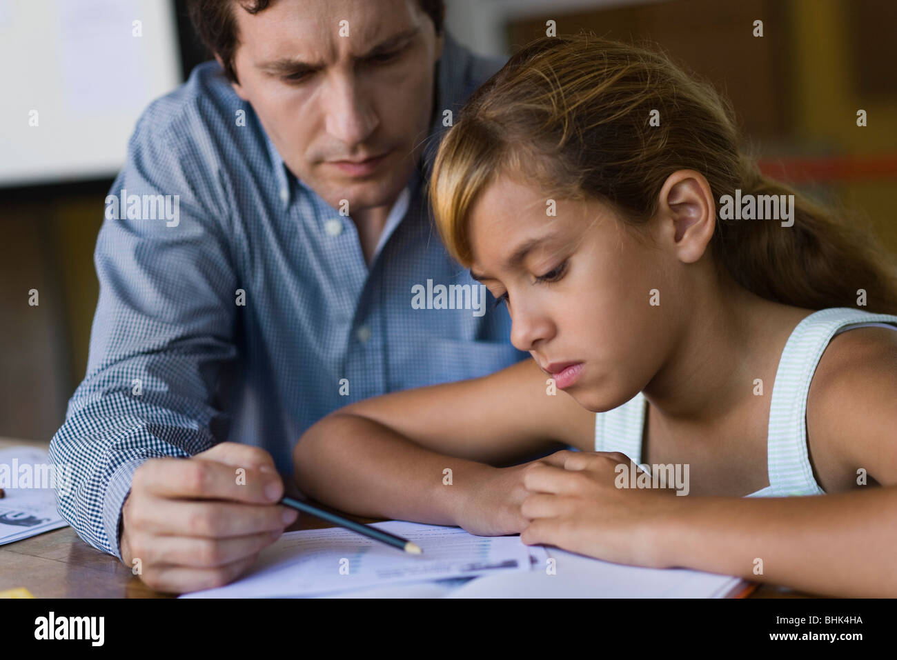 Teacher helping elementary school student in class Stock Photo - Alamy