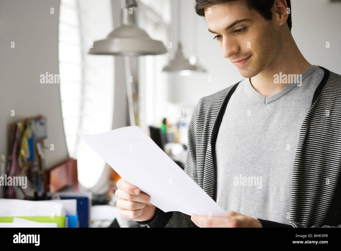Man with look of satisfaction reading document Stock Photo - Alamy