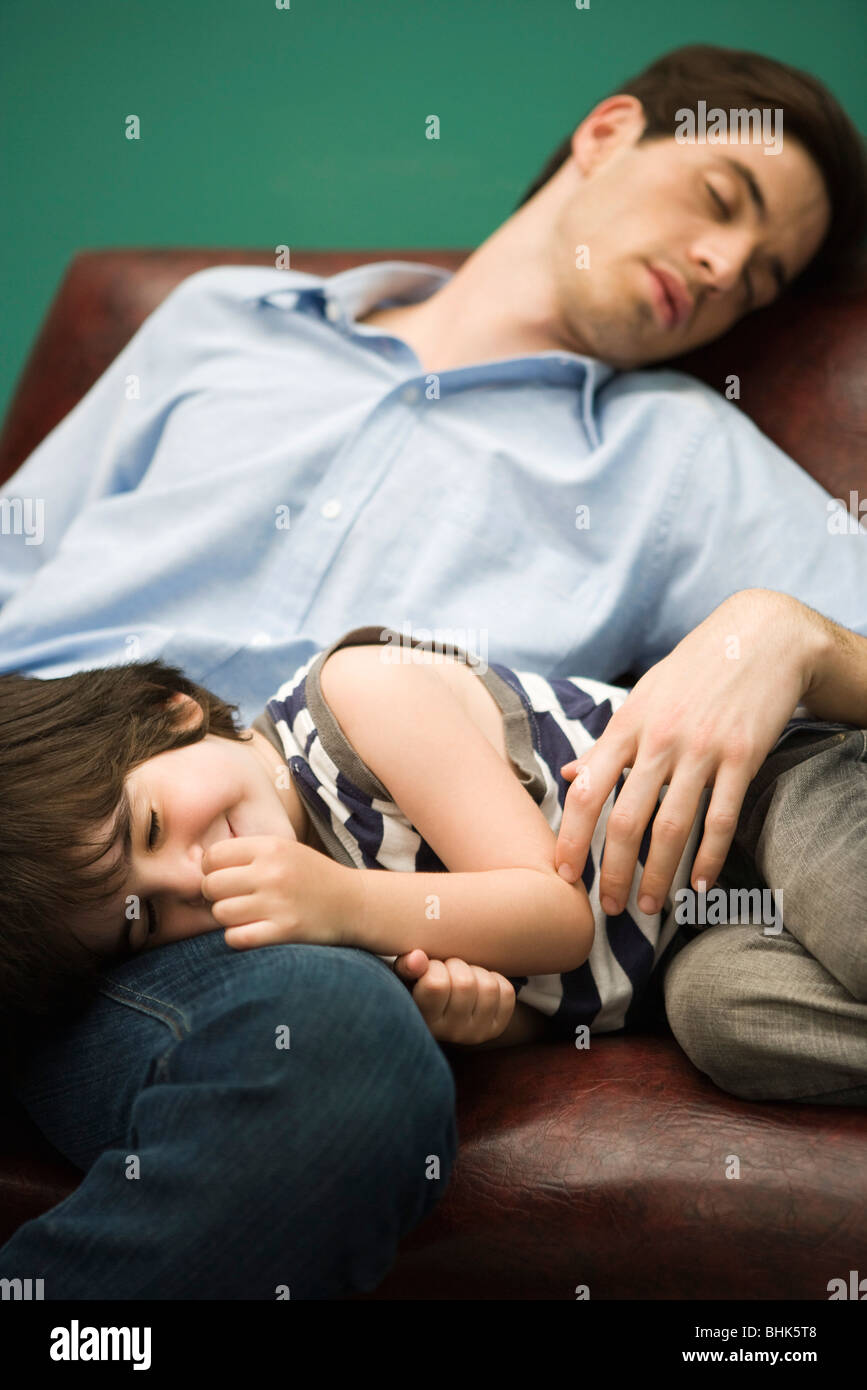Father and son napping together on sofa Stock Photo - Alamy