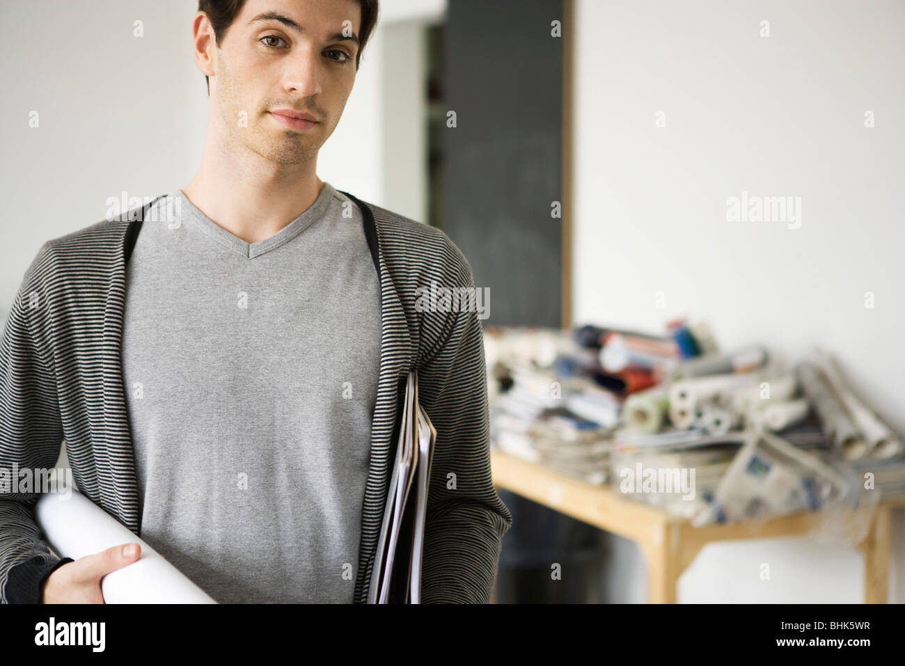 Man carrying rolled up blueprint under arm Stock Photo - Alamy