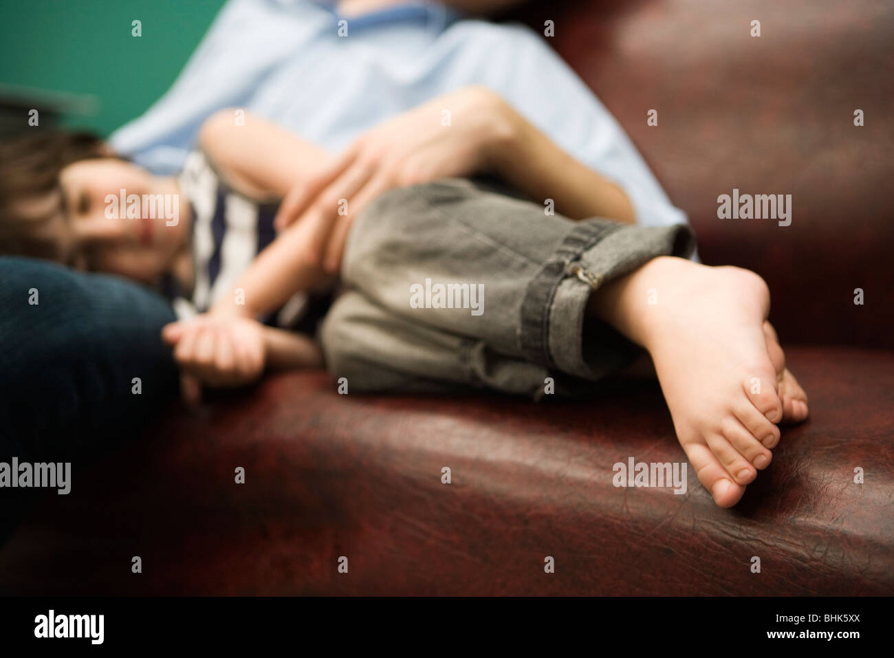 Little boy resting with head in father's lap Stock Photo - Alamy