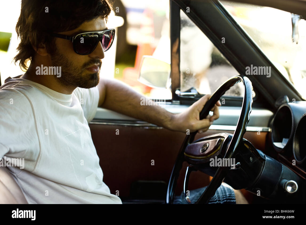 Macho young man driving Stock Photo - Alamy