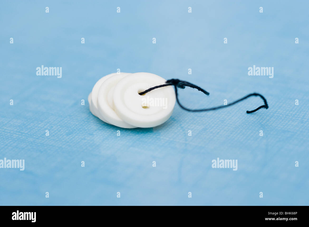 Buttons threaded together Stock Photo - Alamy
