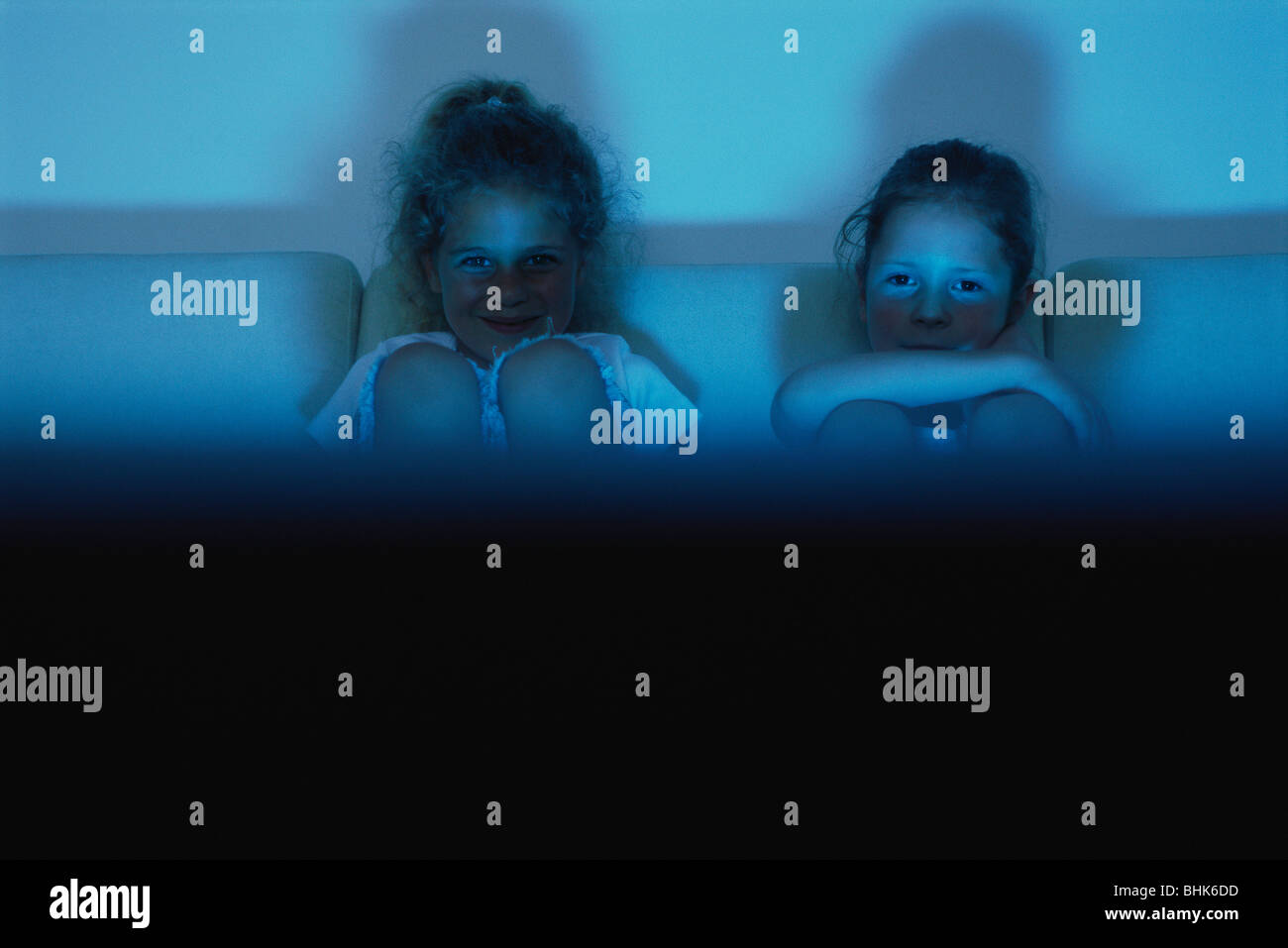Two girls watching TV together at night Stock Photo - Alamy