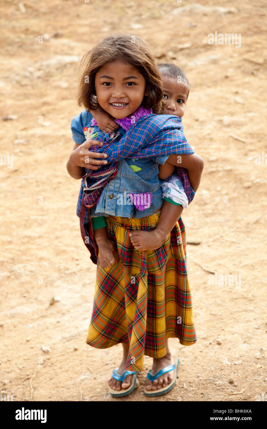 Young girl carrying her little brother around on her back, Ruteng ...