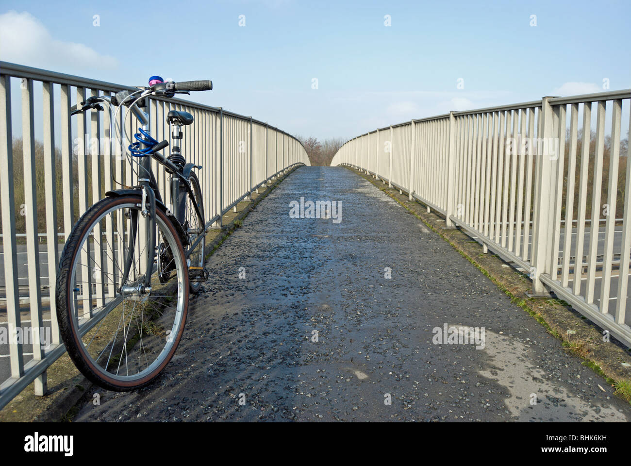 bicycle parked against railings on footbridge over the M3 motorway in ...