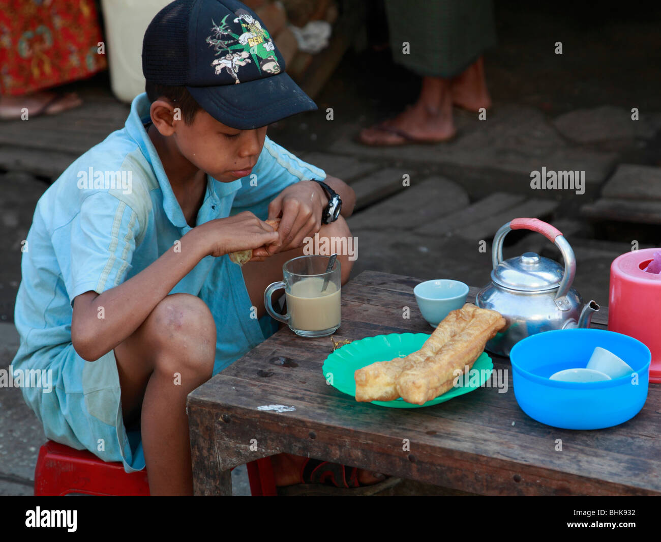 Myanmar, Burma, Yangon, Rangoon, boy eating breakfast in a teashop ...