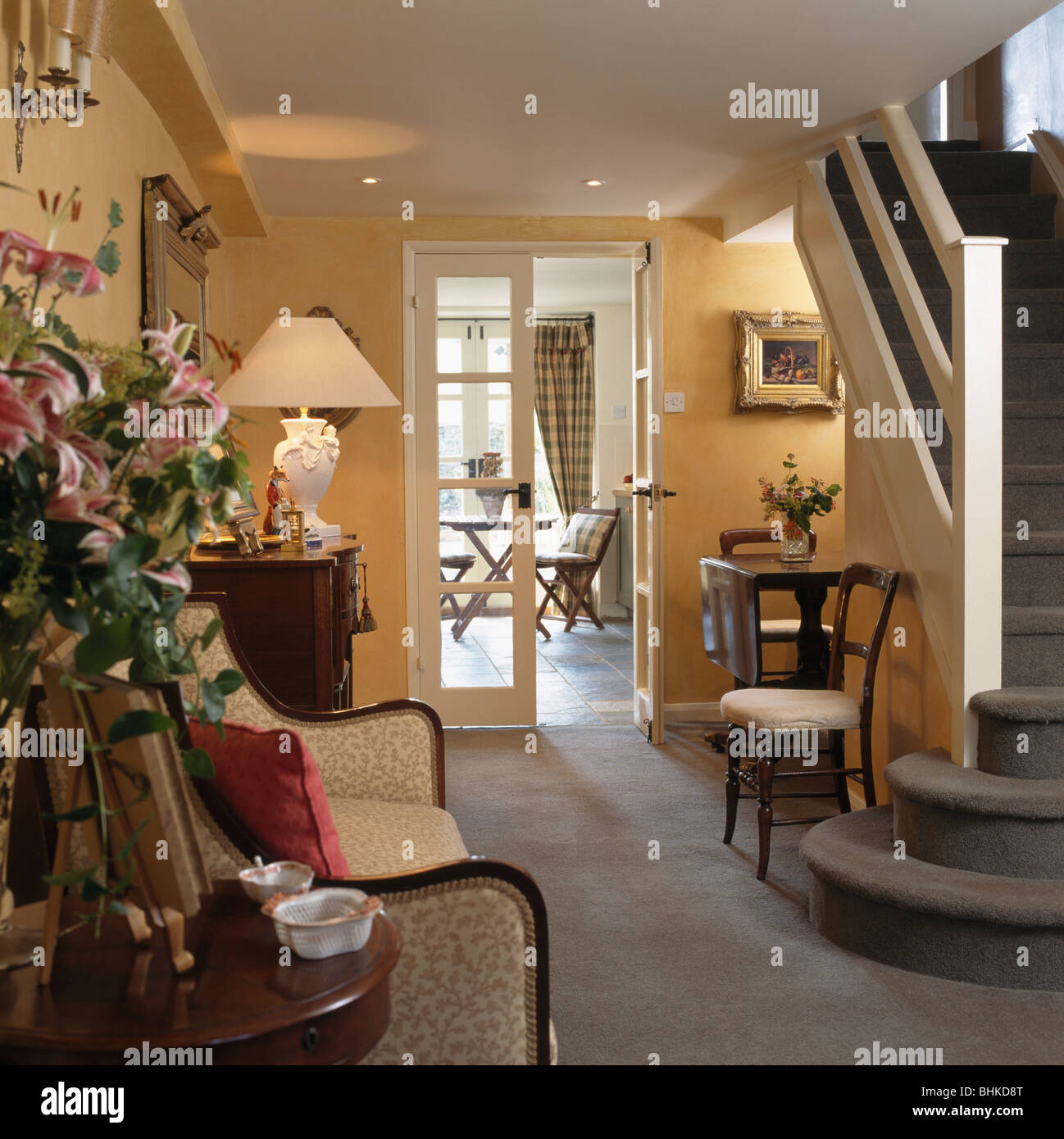 Cream sofa and gray carpet in traditional cream hall with lighted lamp ...