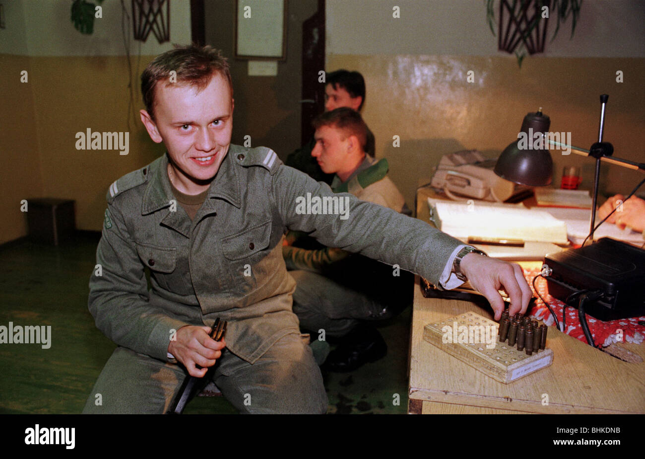 Polish border guard officer preparing a rifle for a night patrol ...