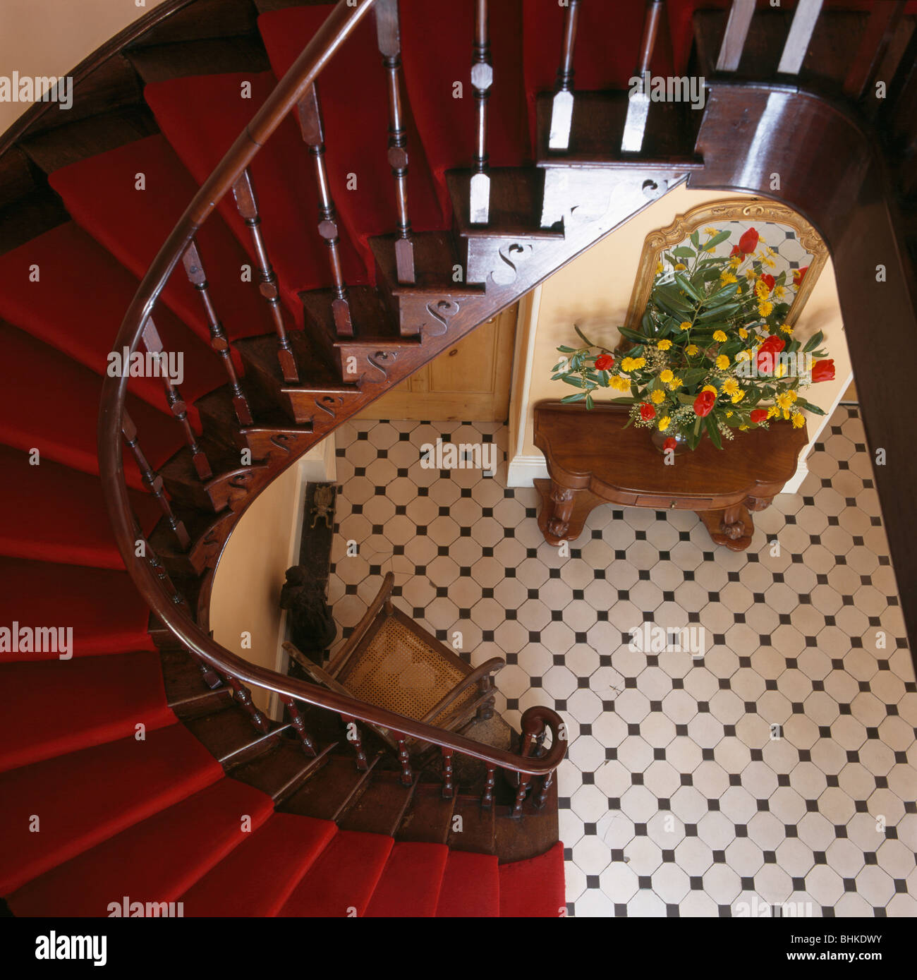 Birdseye view of mahogany staircase with red carpet in traditional hall ...