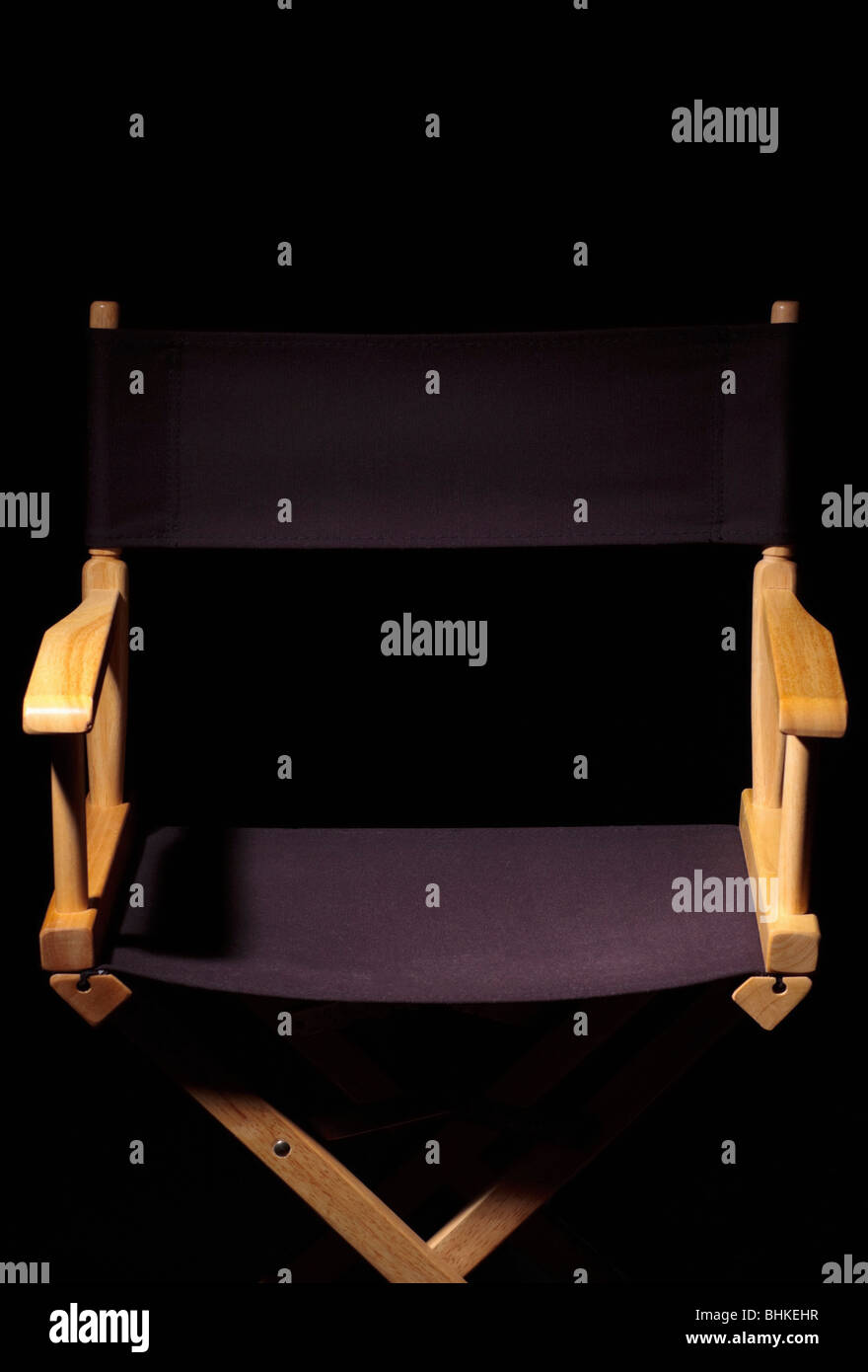 Directors chair lit with spotlight. Isolated. Black background Stock ...