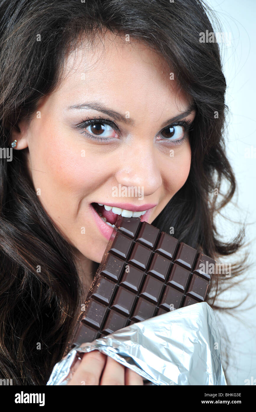 Young woman biting chocolate hi-res stock photography and images - Alamy