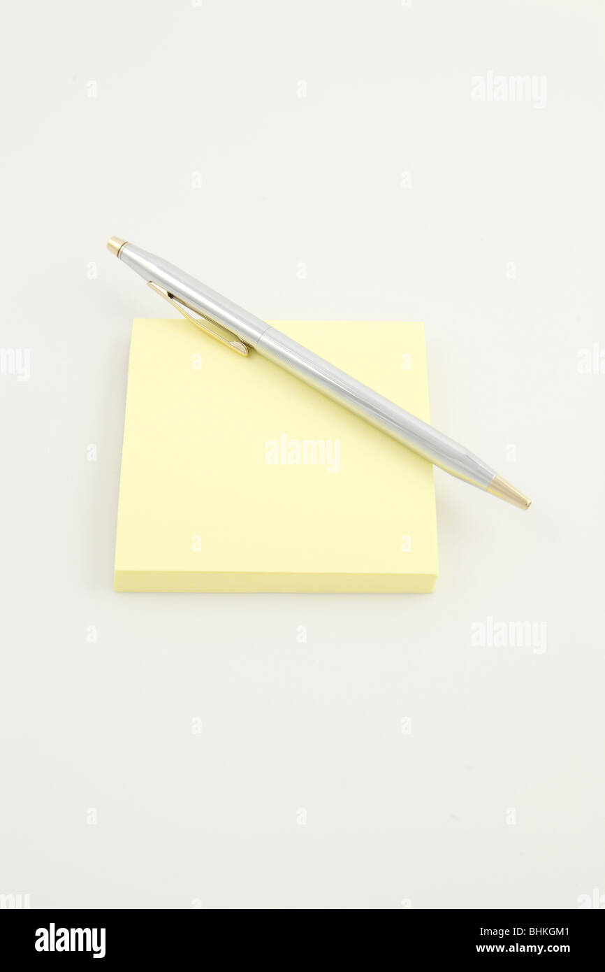 Pen on a yellow sticky note pad Stock Photo - Alamy
