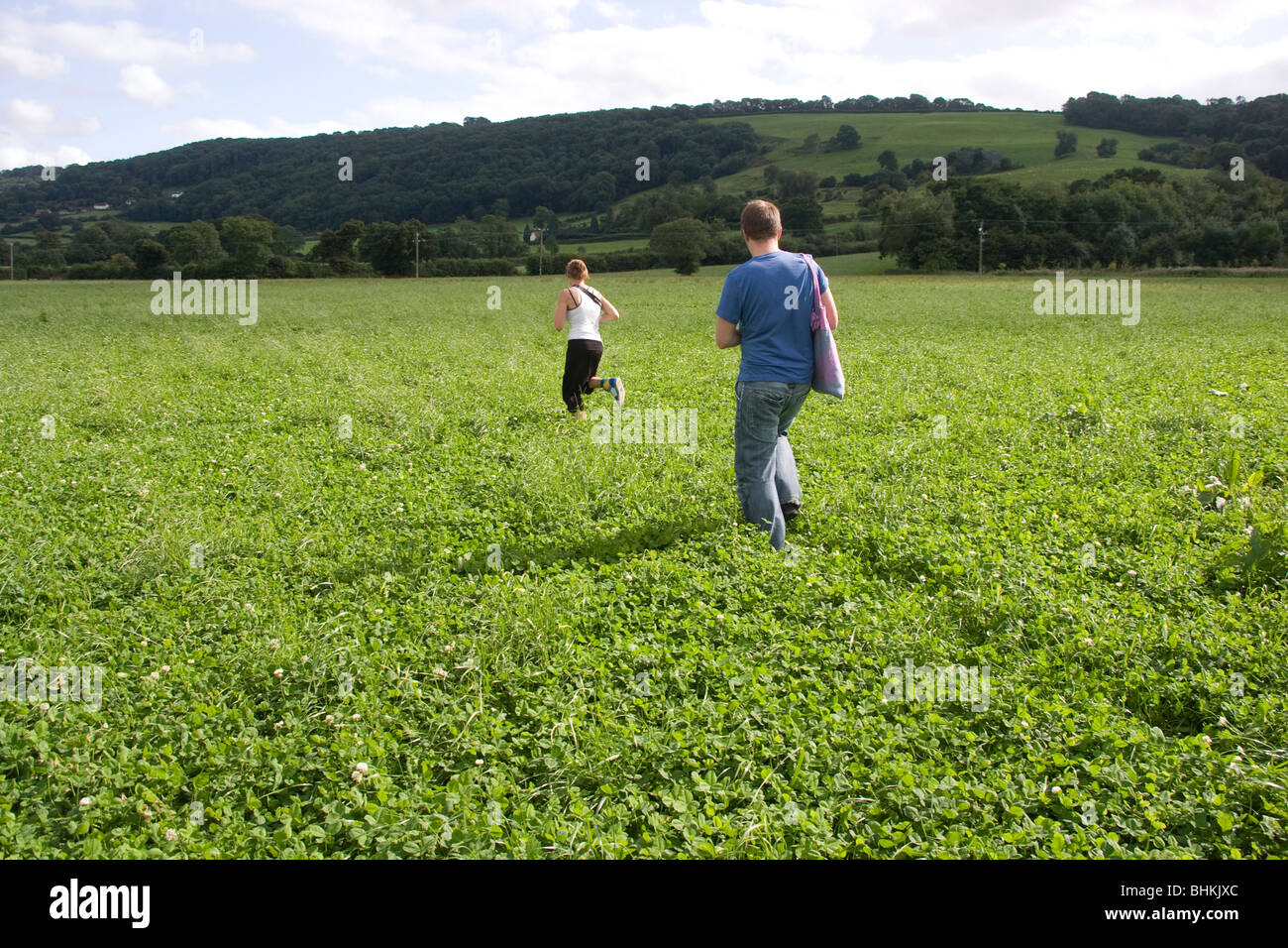 walking through a green field Stock Photo - Alamy
