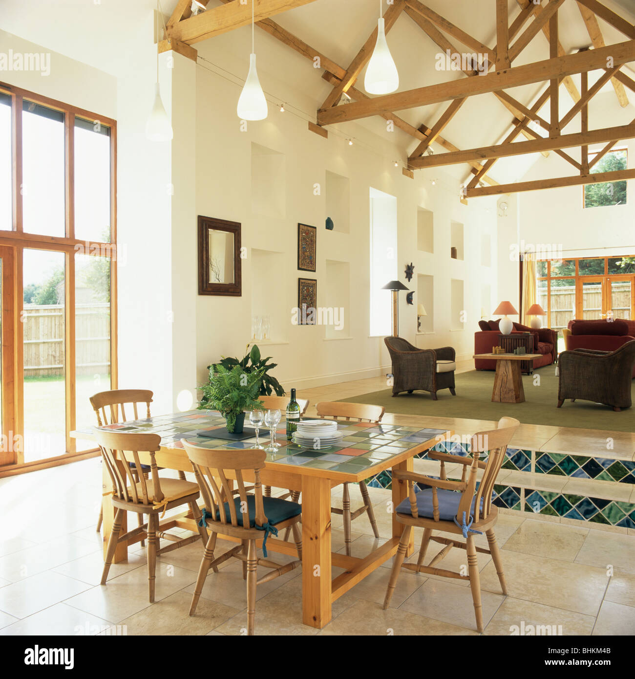 Tiled-topped dining table in open-plan barn conversion with split-level ...