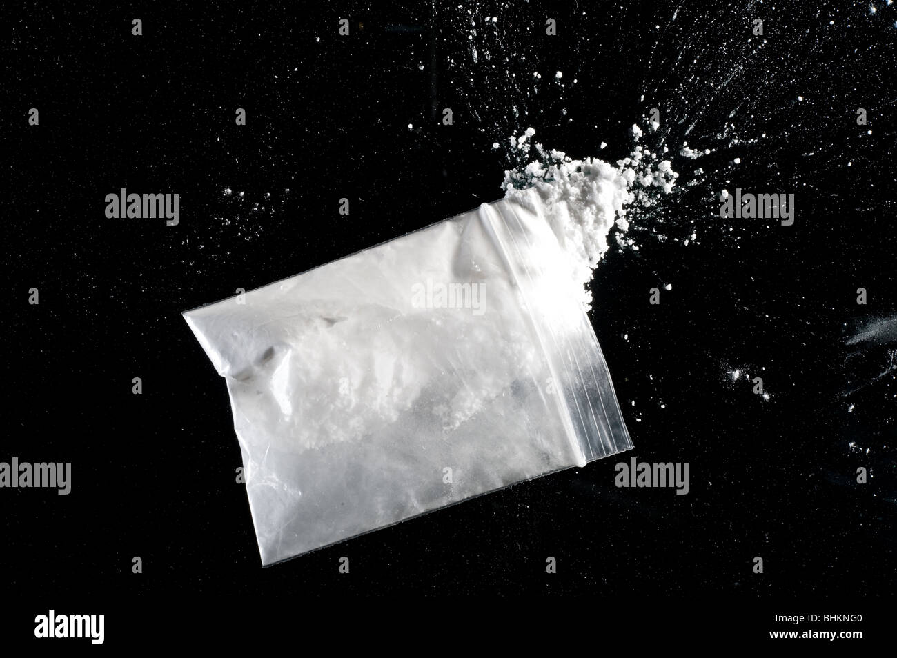 image of bag of cocaine powder spilling out onto black surface Stock ...