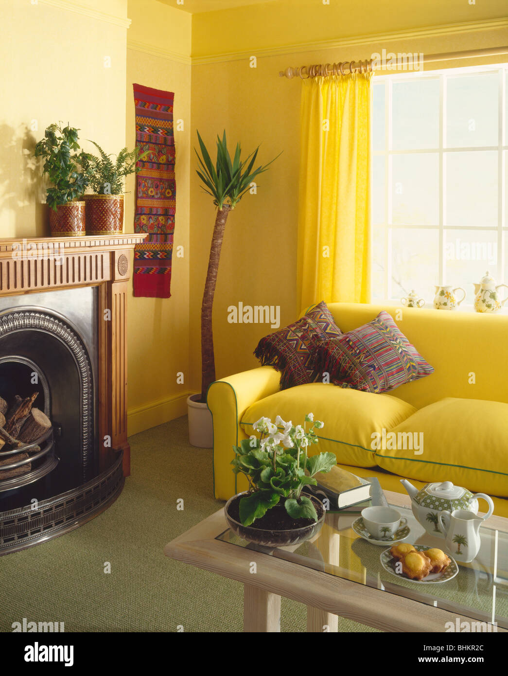 Yellow sofa in front of window with yellow curtains in bright yellow ...