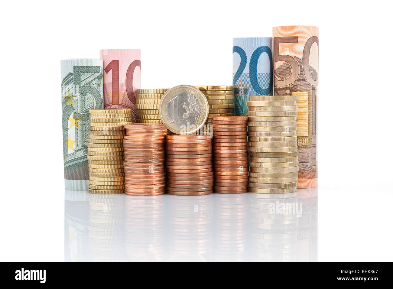 euro coins piled up and rolled bills, five, ten, twenty and fifty euro ...