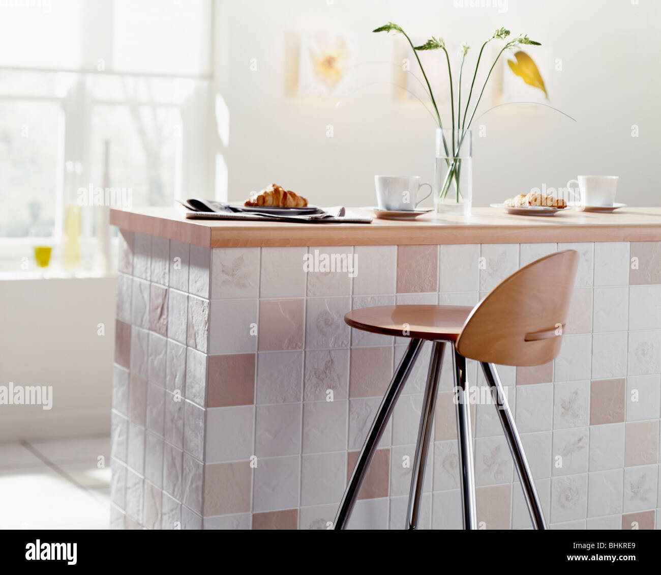 Chrome+wood stool at breakfast bar on tiled peninsular unit in economy ...