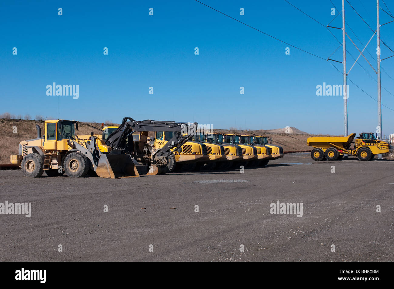 Row of dump trucks and loader Stock Photo - Alamy