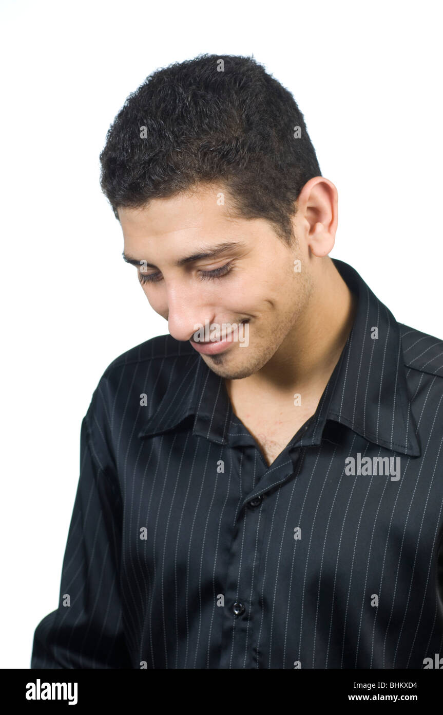 Happy young man looking down smiling against a white background Stock ...