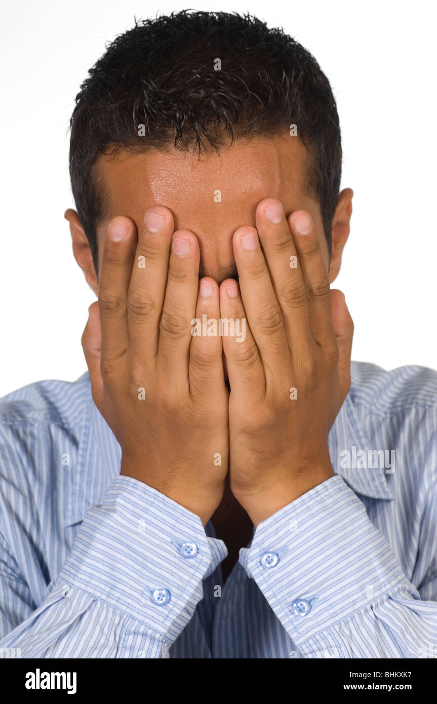 Young man hiding face in hands against a white background Stock Photo ...