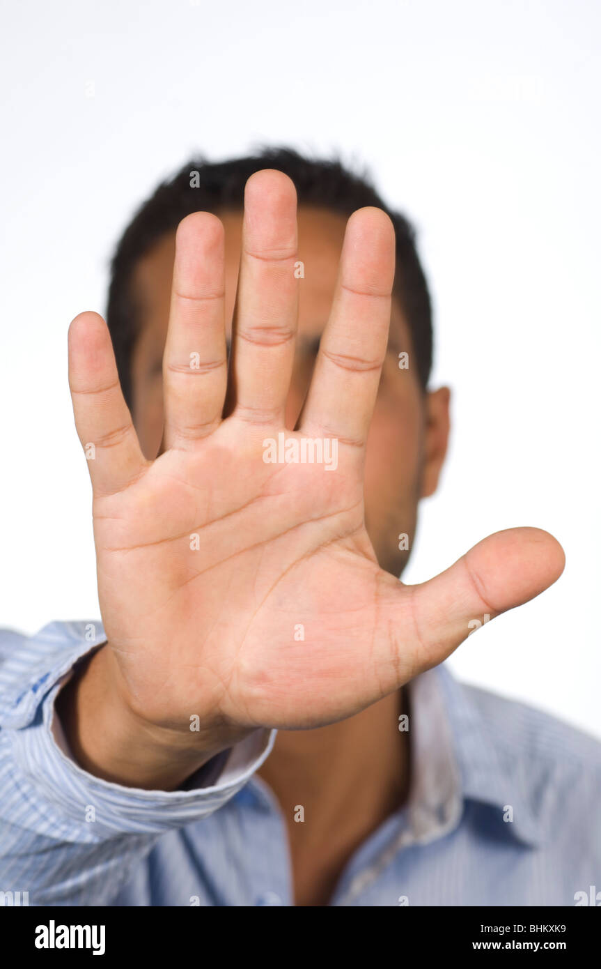 Man showing a stop gesture with his hand against a white background ...