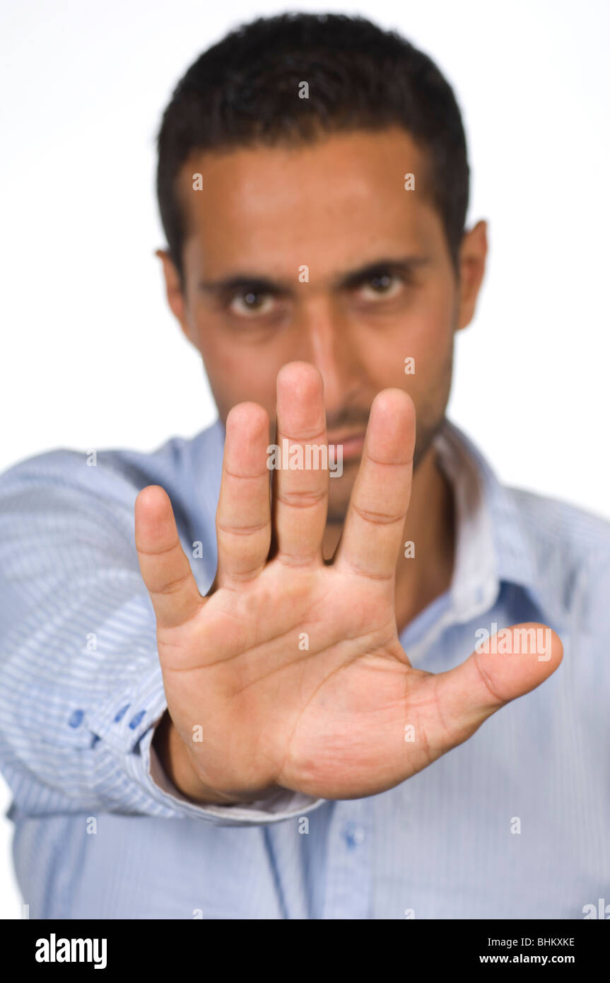 Man showing a stop gesture with his hand against a white background ...