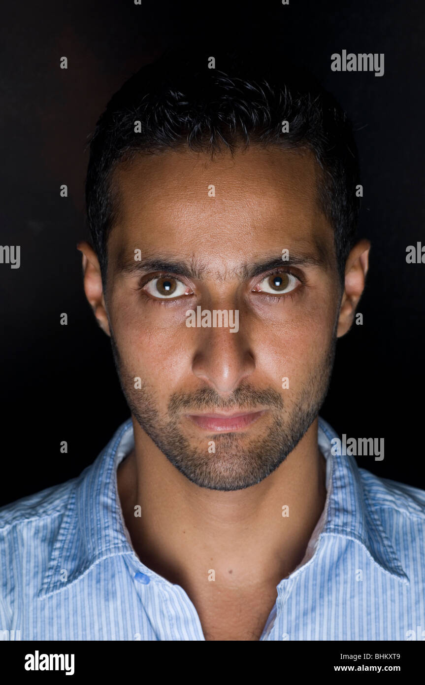 Portrait of an angry young man standing in the dark Stock Photo - Alamy