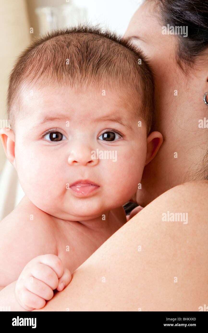 Caucasian Hispanic Latina mother holding cute baby. Infant face with ...
