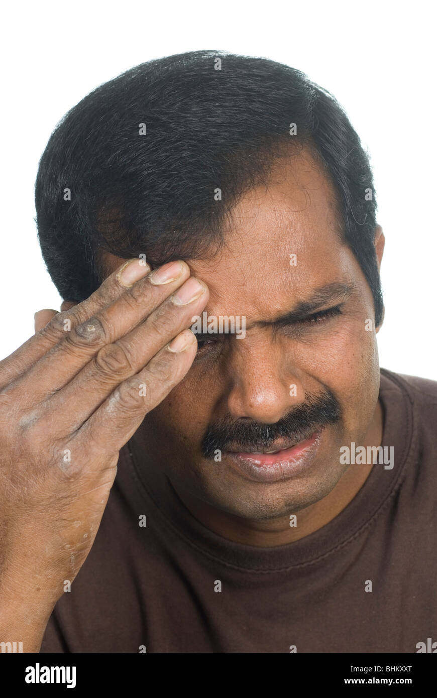 Indian man with a headache against a white background Stock Photo - Alamy