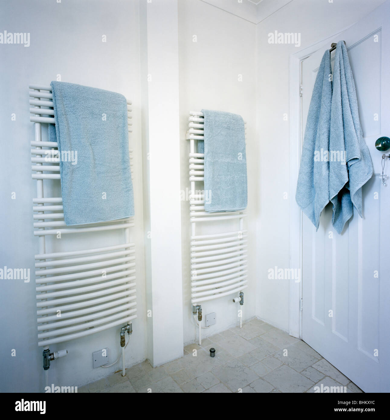 Pastel blue towels on wall-mounted radiators and the back of door in ...
