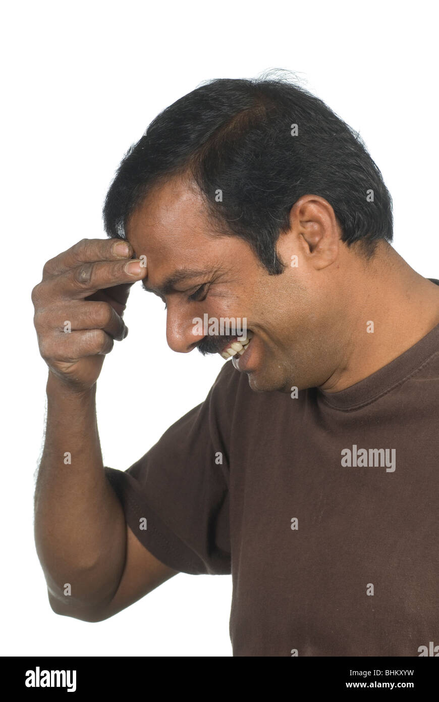 Indian man laughing with hand on forehead against a white background ...
