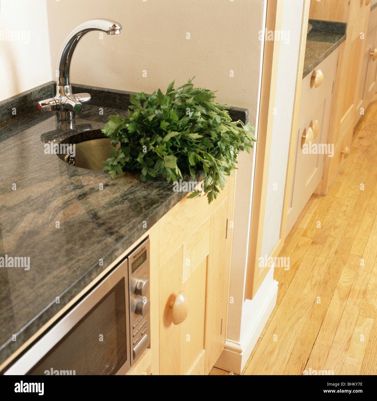 Chrome tap and small circular under-set sink in granite worktop in ...