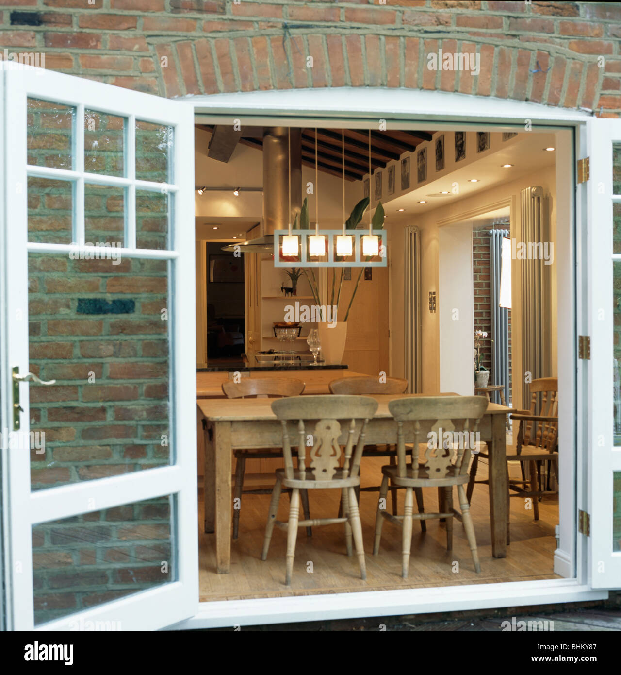 View through open French windows of dining room extension with pine ...