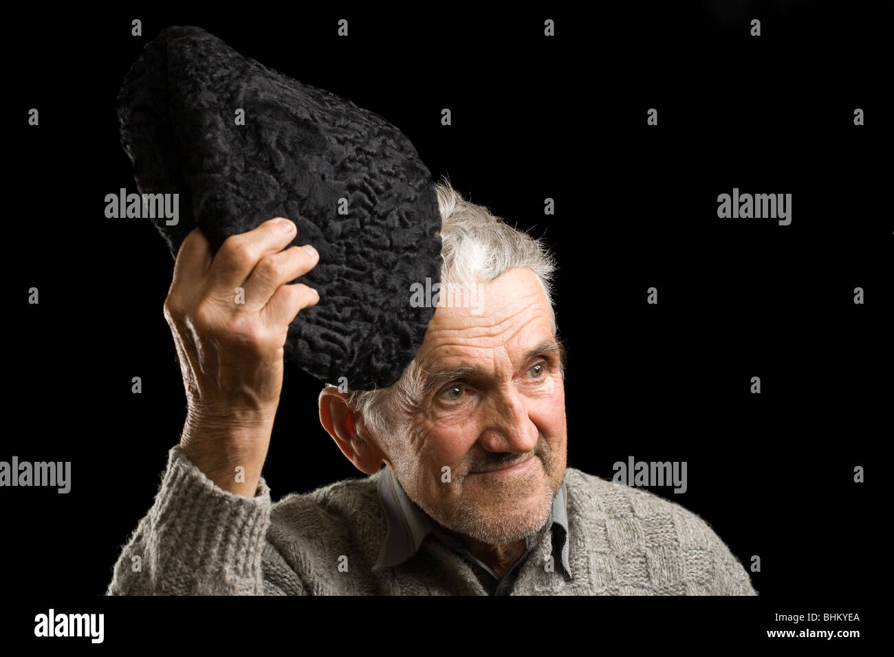 Old man saluting with his cap, isolated on black Stock Photo - Alamy