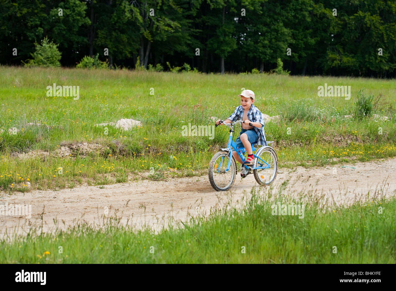 Beautiful boy riding a bike on a country road Stock Photo - Alamy