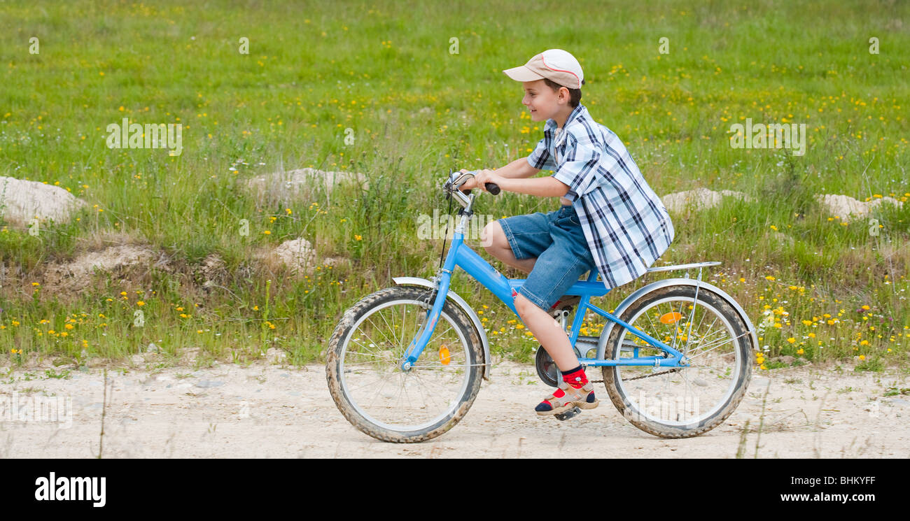 Beautiful boy riding a bike on a country road Stock Photo - Alamy