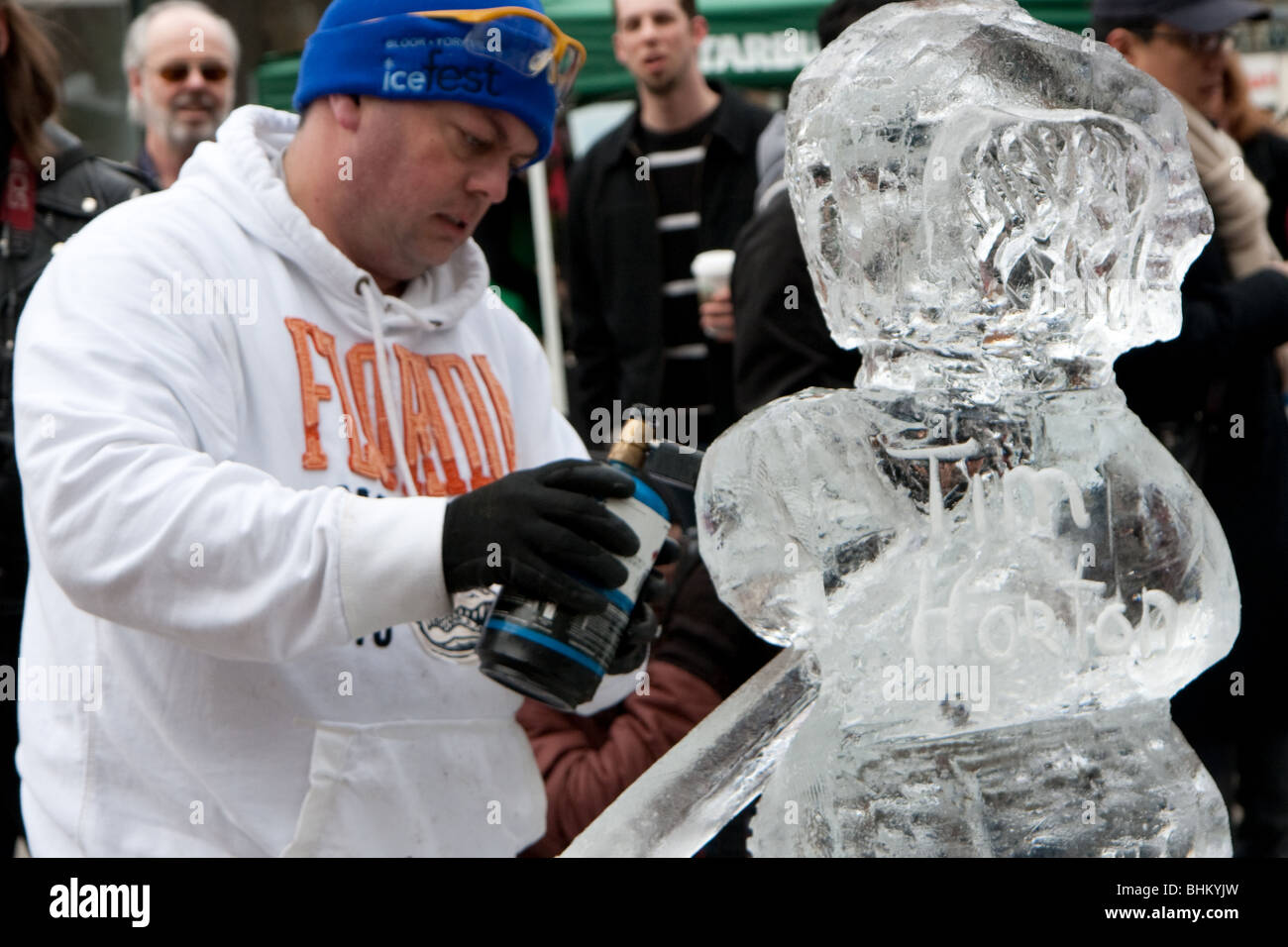 Ice craving artist working on his artistic creation while spectators ...
