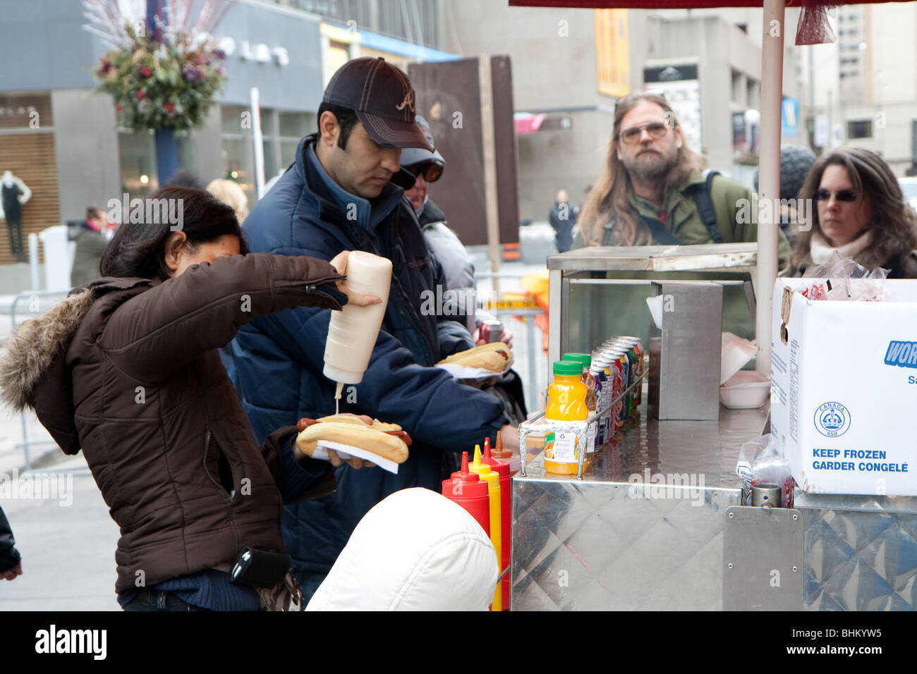 Customers lining up at a hotdog stand during a cloudy toronto winter ...