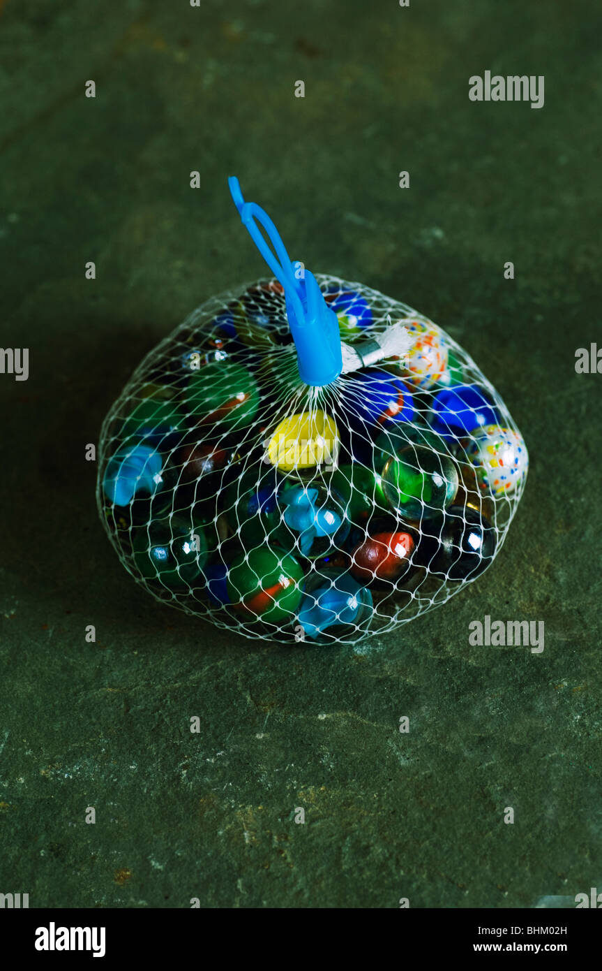 Traditional children glass marbles inside a net Stock Photo - Alamy