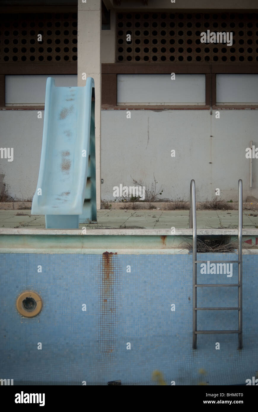 A dilapidated empty swimming pool at a closed down resort Stock Photo ...